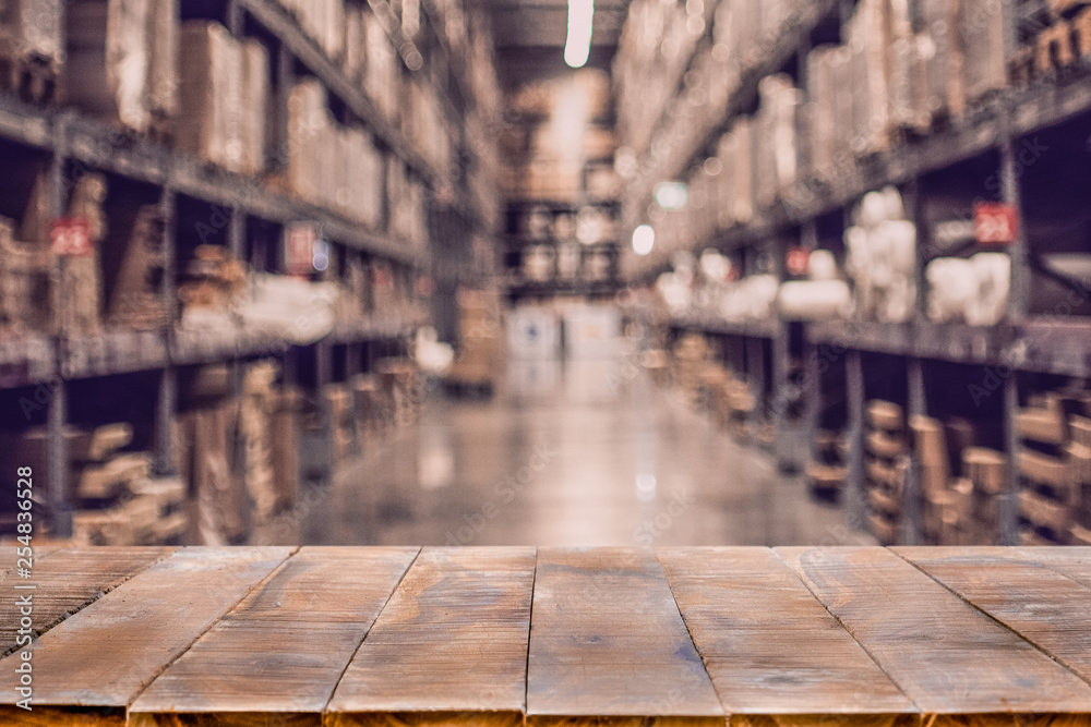 Empty wooden table on defocused blurred boxes on rows of shelves. Stock ...