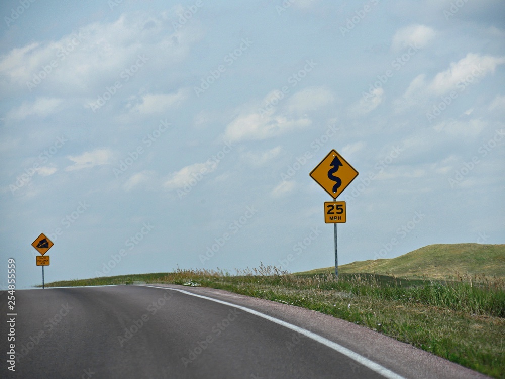 Road signs warning motorists of a curve and dangerous slope with road ...