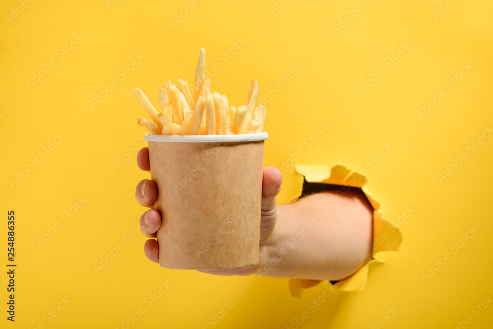 Hand giving French fries Stock Photo | Adobe Stock