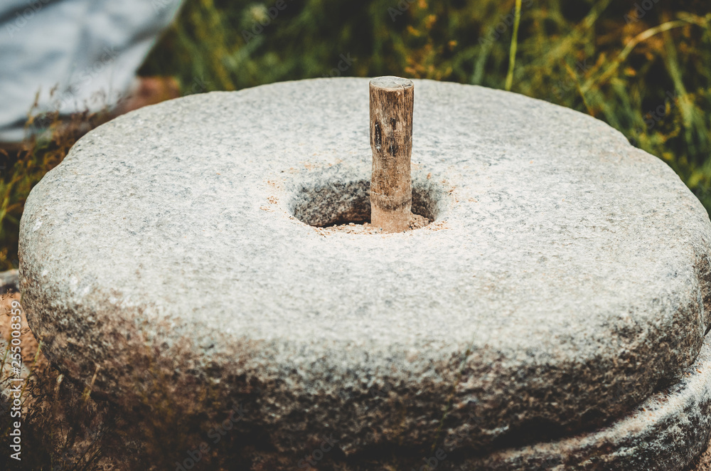 The ancient stone hand mill with grain. Medieval hand-driven millstone ...