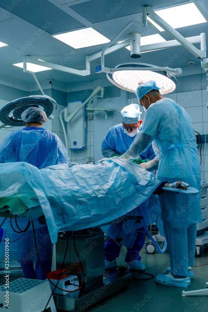 Team of professional surgeons operating on patients with diseases ...