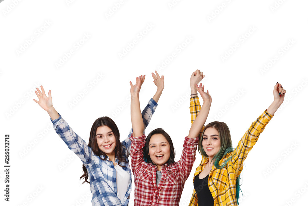 three beautiful young girls with their hands up happily. isolated on ...