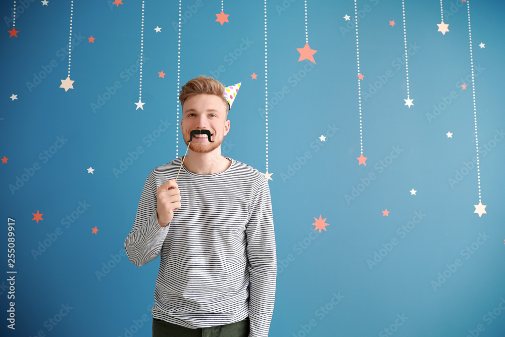 Funny man with party decor for April Fools' Day on color background ...