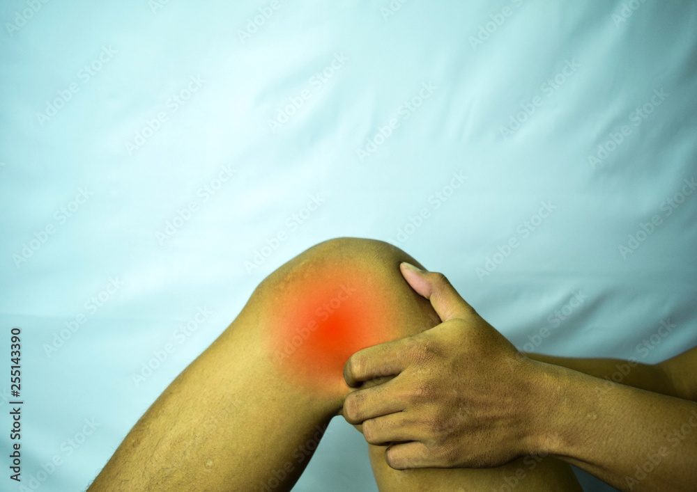 suffering from joint pain with red spot. Hands on leg as hurt from ...