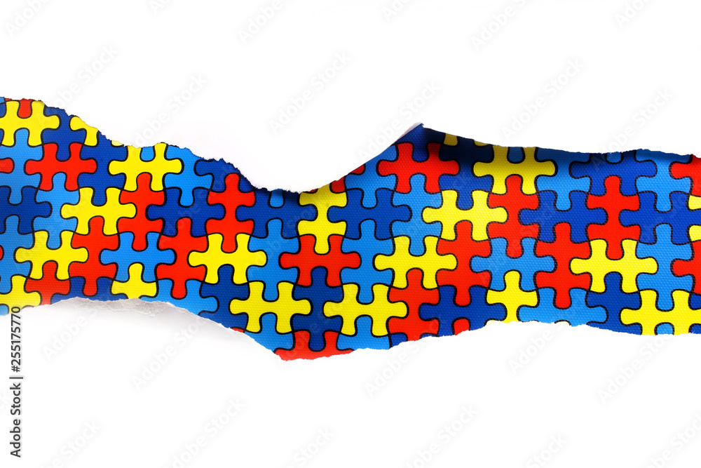torn white paper on multicolored puzzle background. Cocept for autism ...