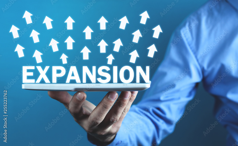 Man holding Expansion text with arrows. Stock Photo | Adobe Stock