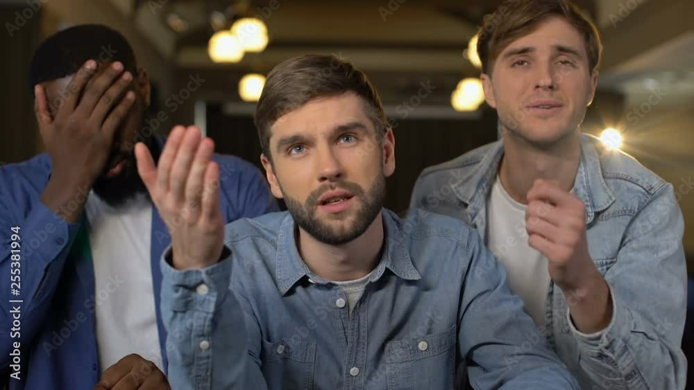 Three male fans feeling upset game loss, watching competition together ...