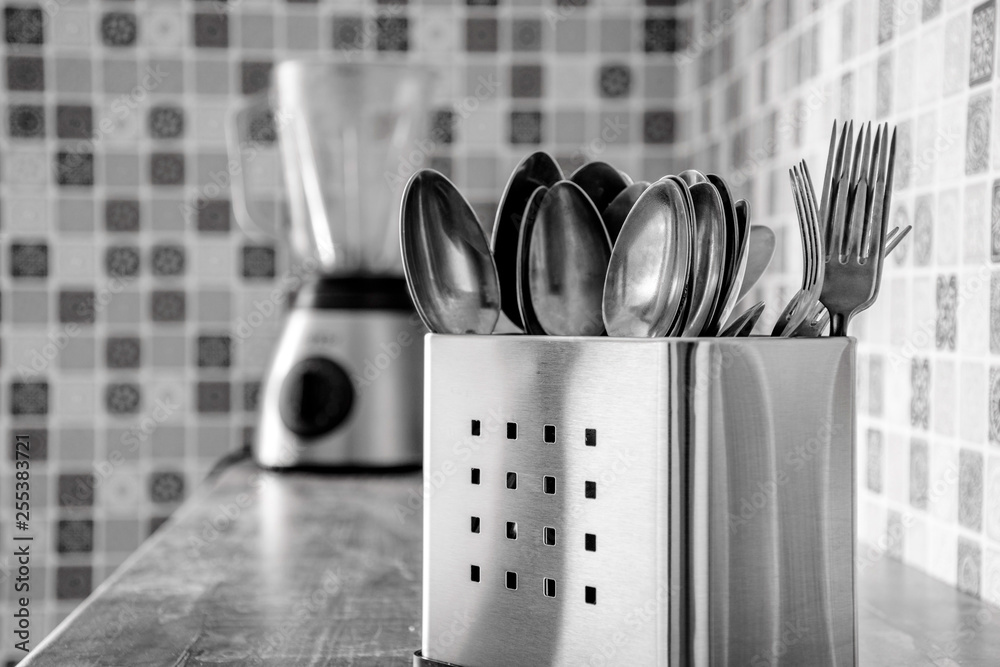 Inox stand with cutlery set spoon and forks on a wooden board in ...
