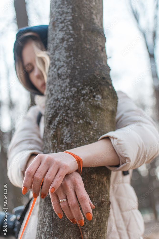 Restraint of women concept. A woman with her hands tied to a tree ...