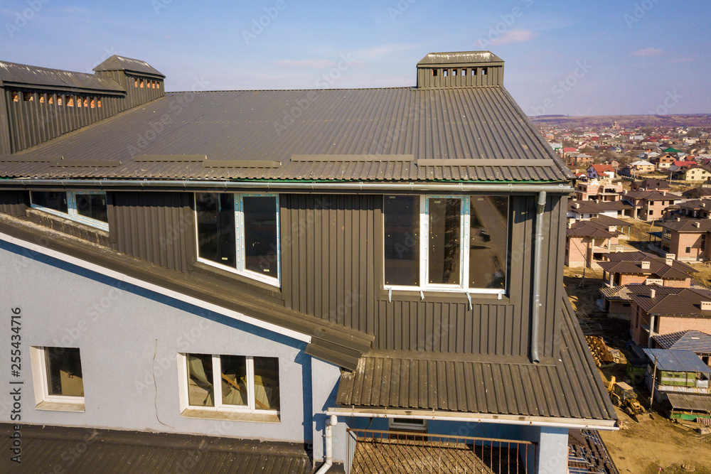 Aerial view of attic annex room exterior with plastic windows, roof and ...