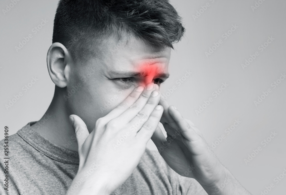 Sad man holding his nose because sinus pain Stock Photo | Adobe Stock