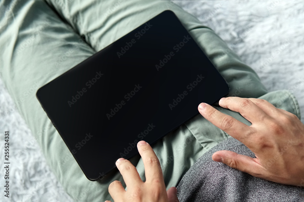 Close up of a young man on the sofa touching the black screen of a ...