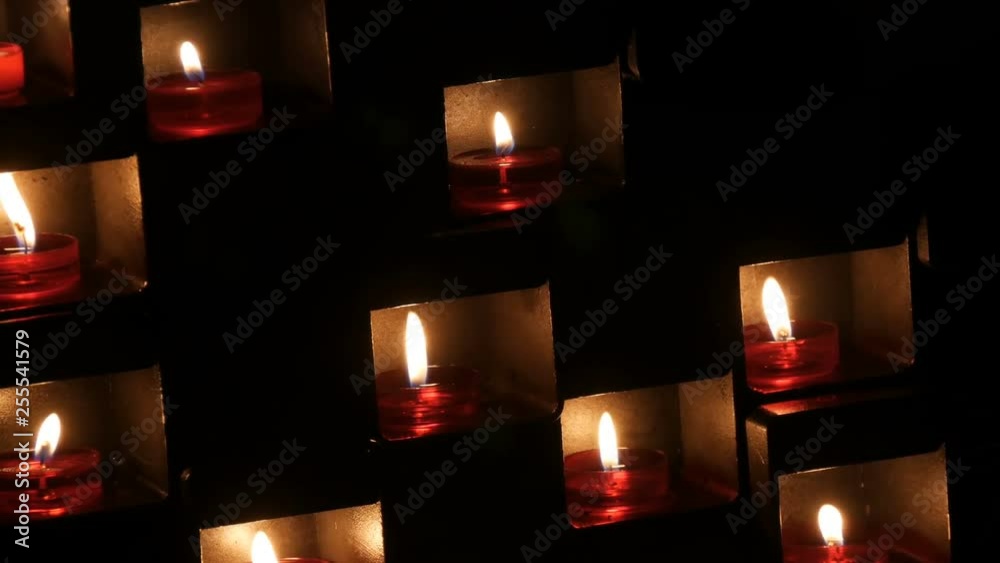 Beautiful red church candles for prayers in special niches in a ...
