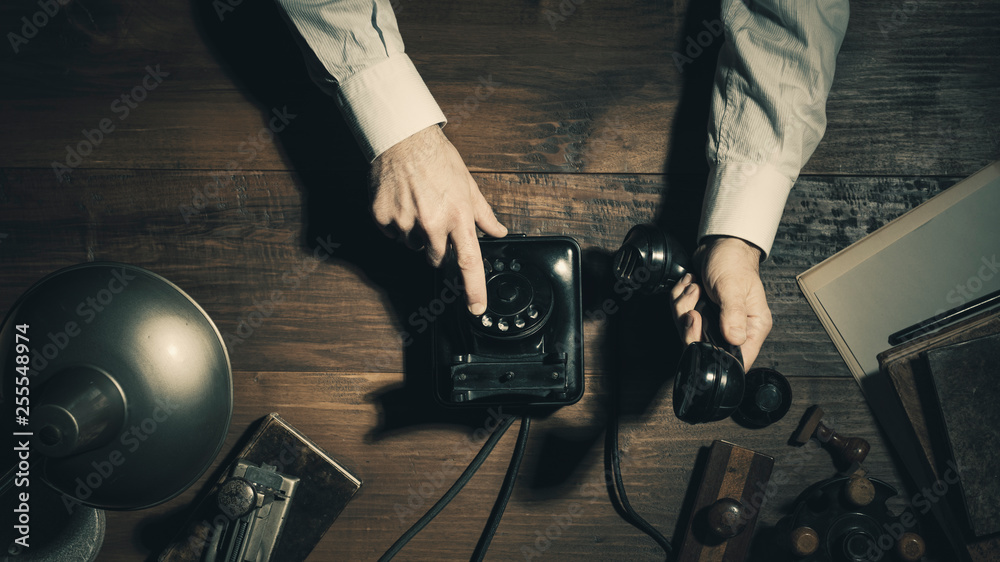 Office worker making a phone call late at night in a vintage office ...