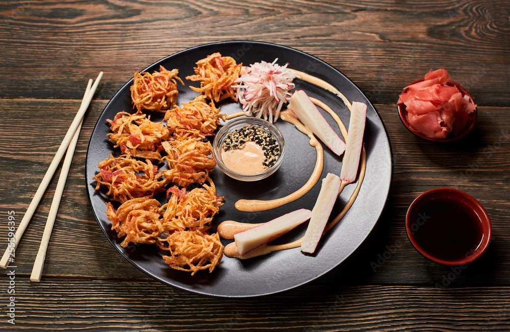 Exotic tempura fries dish in black plate with crab sticks, mayonnaise ...