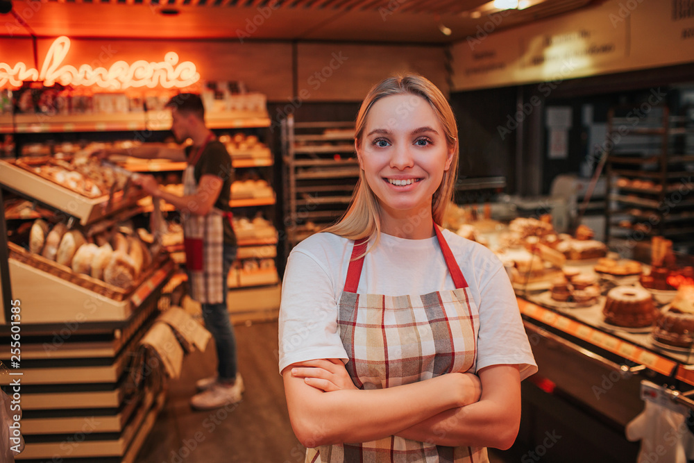 Happy young woman stand in grocery store. She pose nad look on camera ...