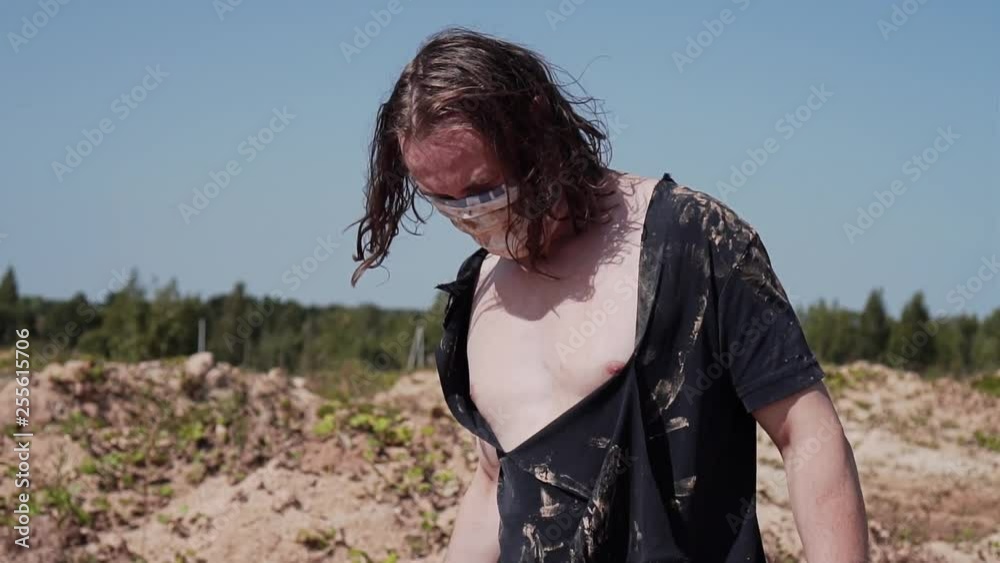 Vidéo Stock A tramp in dirty and torn clothes is walking in the desert ...