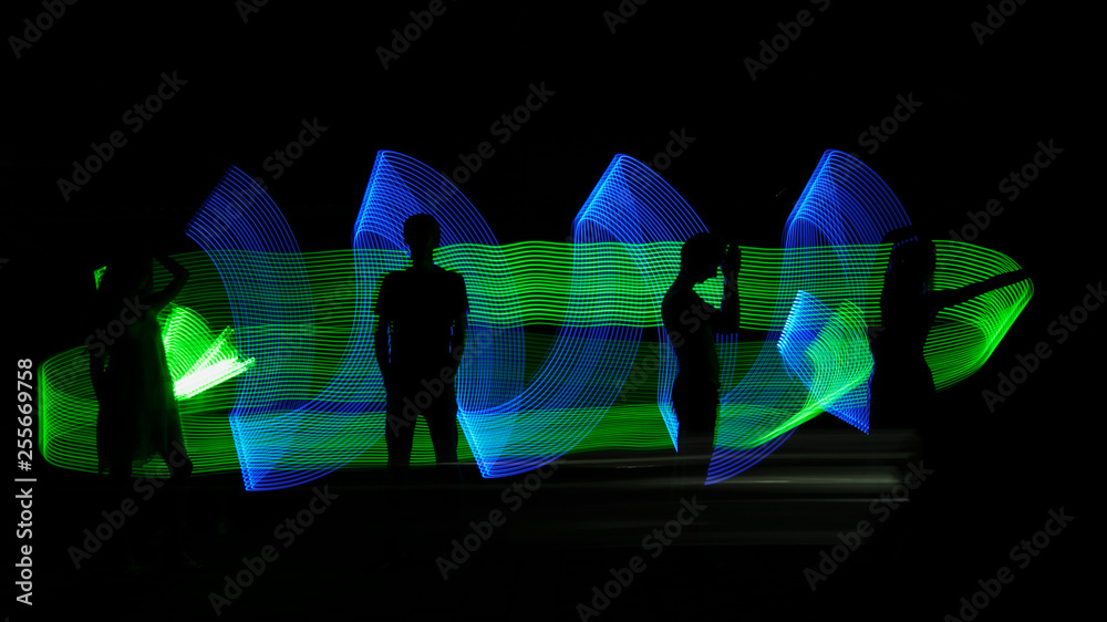 Human silhouette against green and blue abstract backlight on black ...