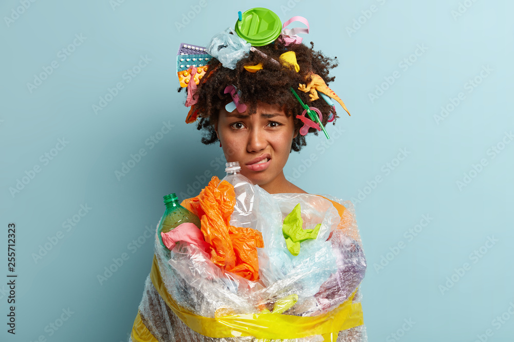 Plastic pollution problem. Dissatisfied woman wrapped in polythene ...