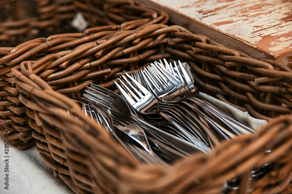 wicker basket with forks in the restaurant. many forks in a wicker box ...