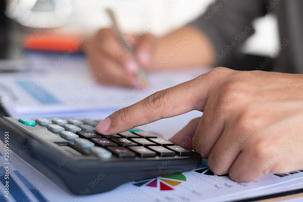 Man working with a calculator calculate and analyzing budget at the ...