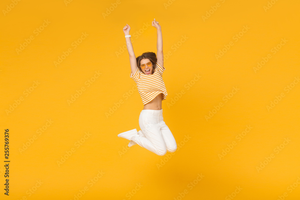 Successful young female acts like winner, jumping high in the air with ...