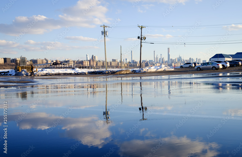 Puddle water reflection of sky clouds and power line. Above ground ...