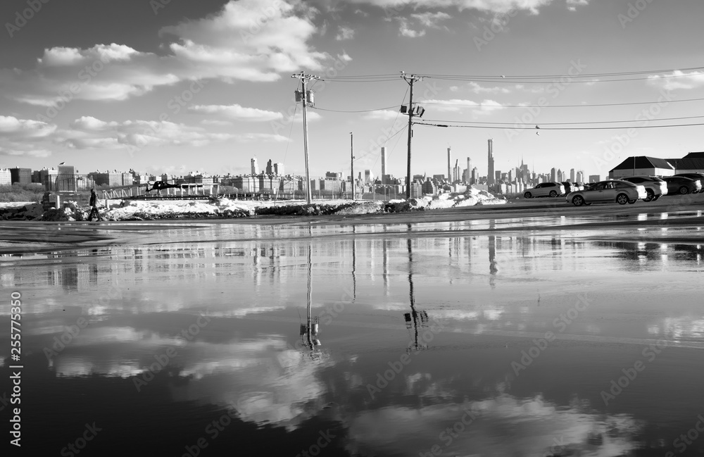 Puddle water reflection of sky clouds and power line. Above ground ...