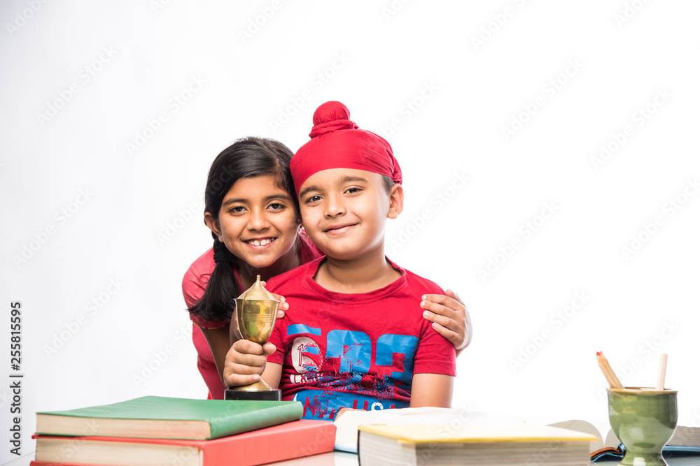 Indian sikh/Punjabi boy and girl studying with books and laptop ...