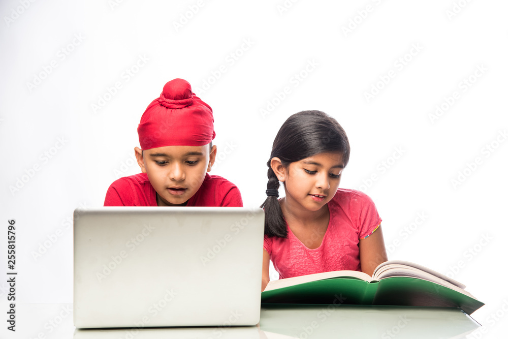 Indian sikh/Punjabi boy and girl studying with books and laptop ...