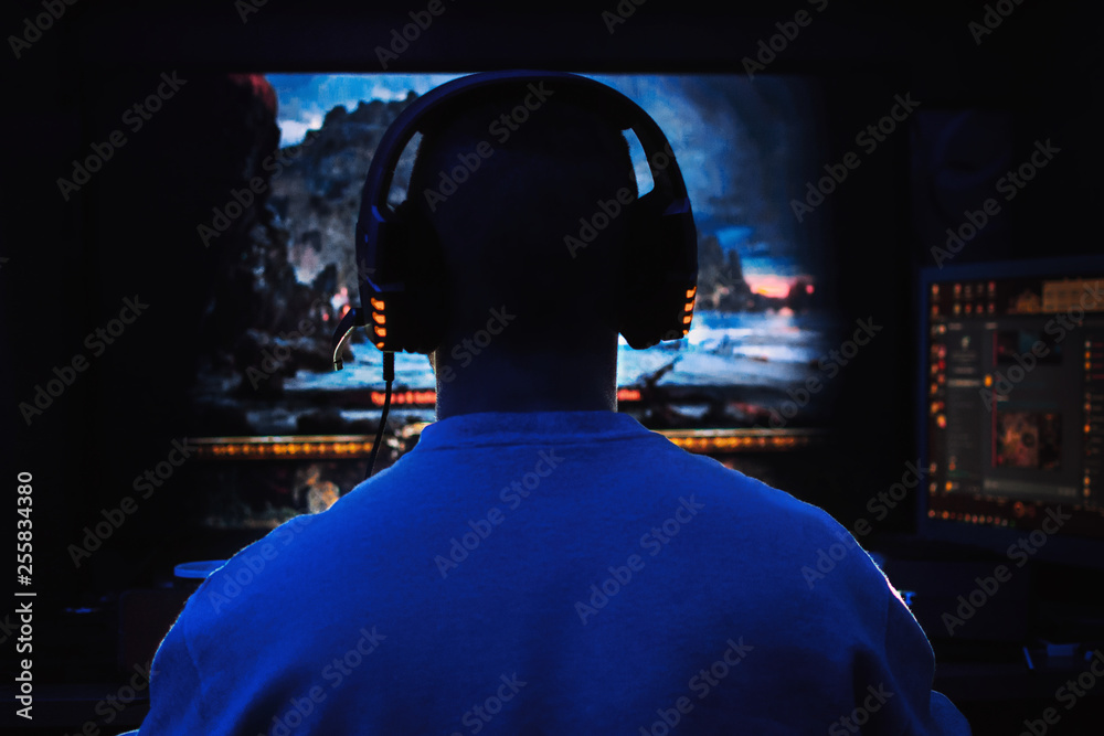 Men wearing headphones playing video games late at night Stock Photo ...