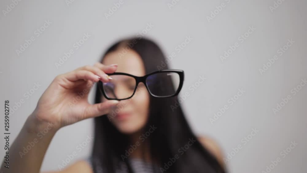 Pretty woman shows from left to right stylish eyeglasses and puts them ...