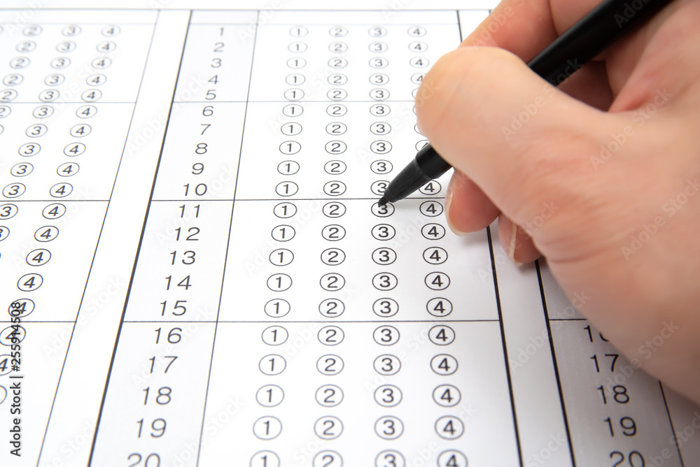 Man is filling OMR sheet handing with pen. Stock Photo | Adobe Stock Man is filling OMR sheet handing with pen. Stock Photo | Adobe Stock
