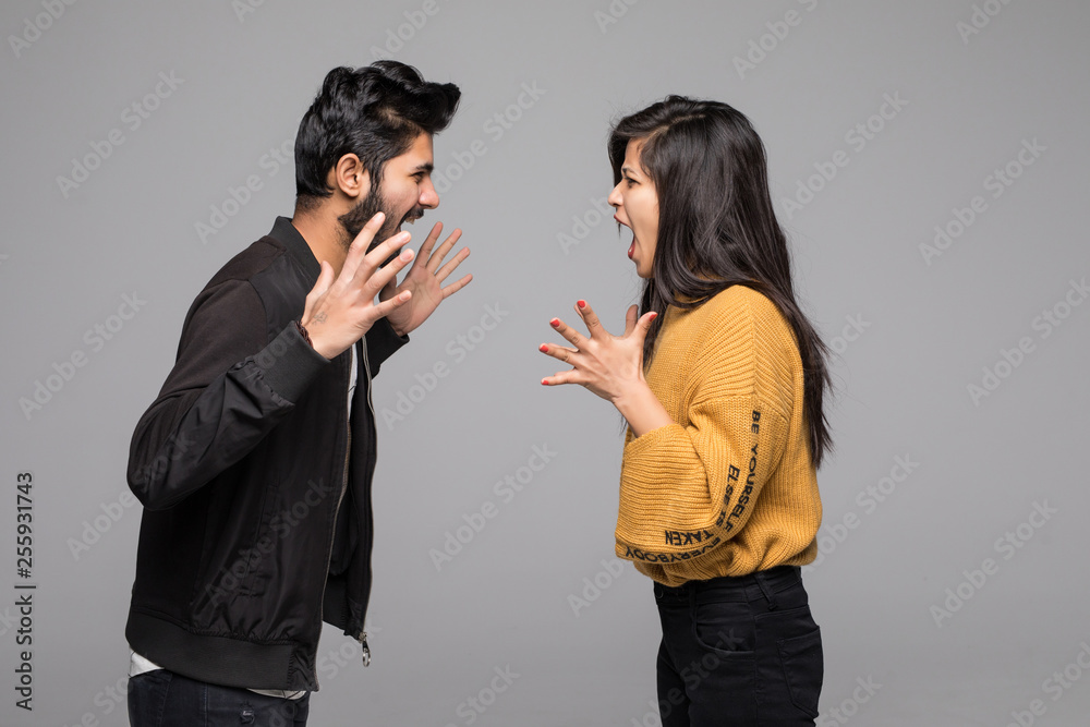 Angry indian couple shouting at each other quarrel on gray background ...