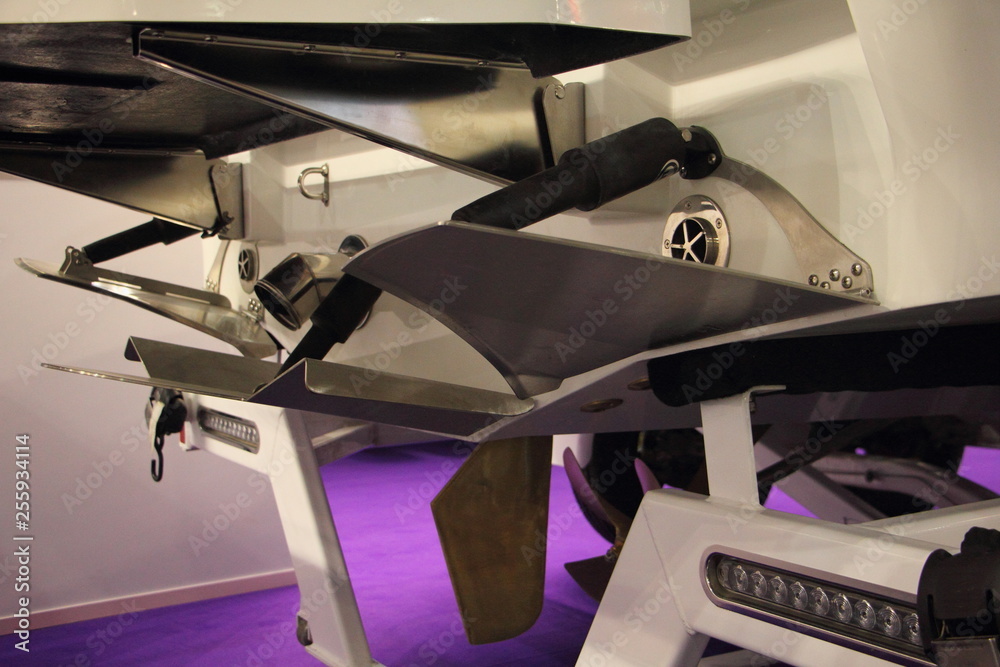 Transom of motor boat with trim tabs and rudder blade on white boat ...