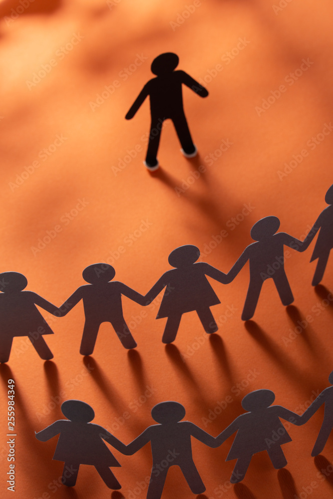 Paper human figure standing in front of paper people holding hands on ...