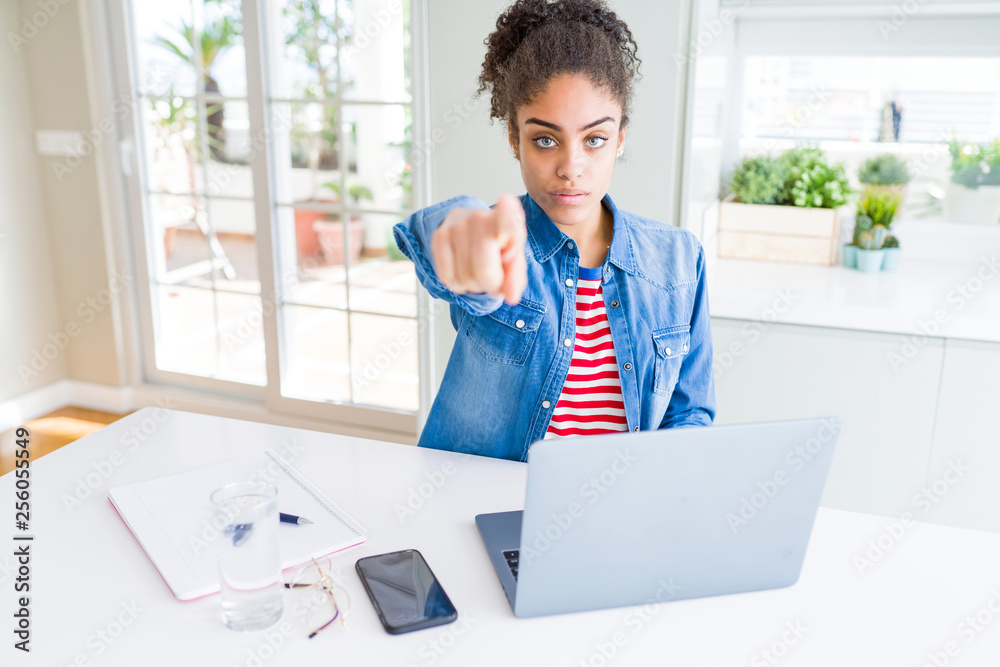 Young african american student woman using computer laptop pointing ...
