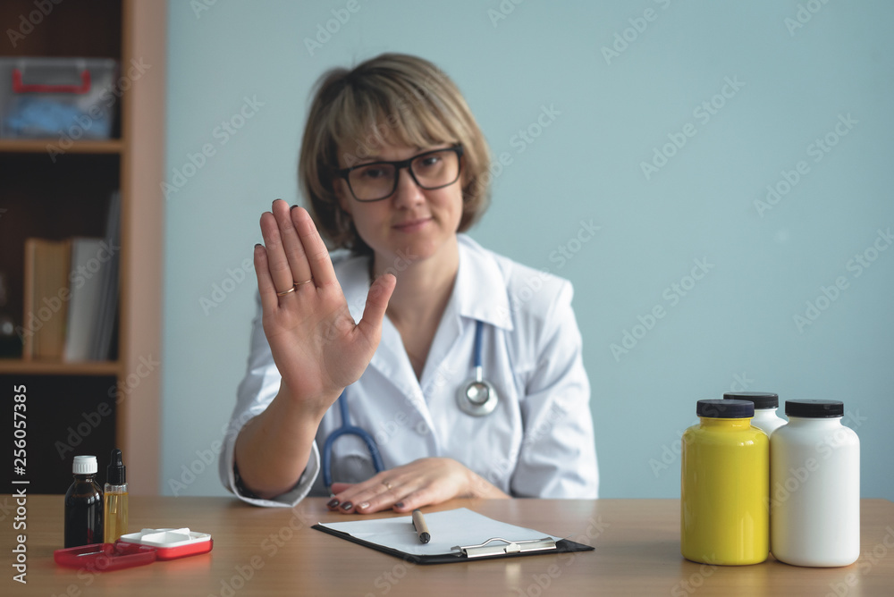 Woman a doctor is showing a stop gesture by her hand. No panic. Do not ...