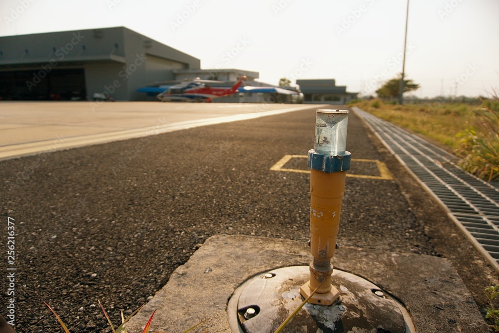 Taxiway light with helicopter on background. Helicopter parking on ramp ...
