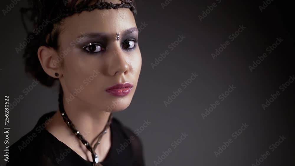 Young beautiful girl posing in front of the camera. Her hair is in the ...