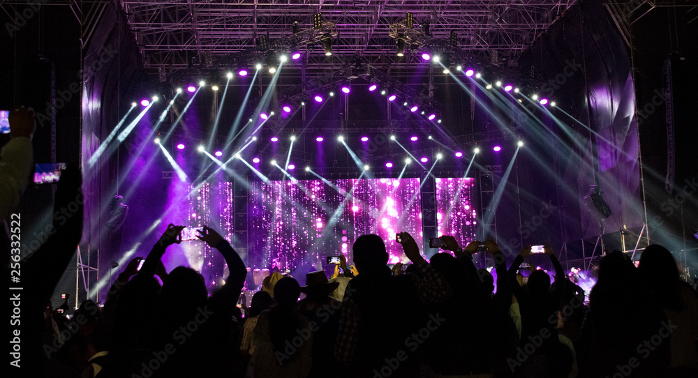 Group of people in outdoor concert, illuminated stage, high technology ...