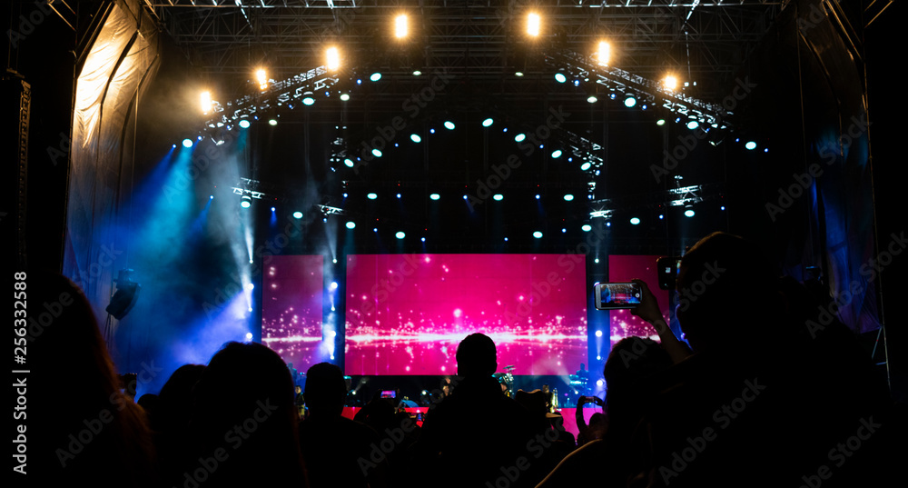 Group of people in outdoor concert, illuminated stage, high technology ...