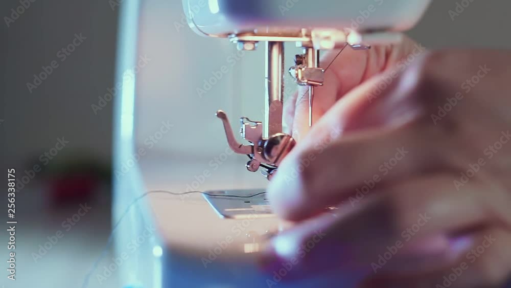 Extra close-up, sewing needle on the machine, the hand of the ...