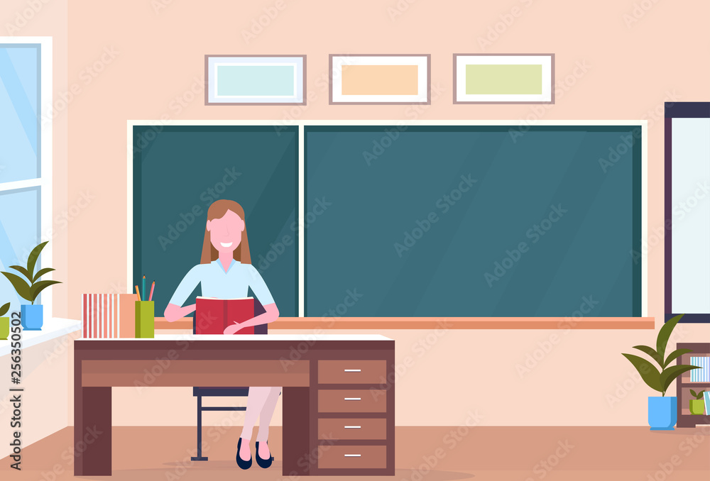 woman teacher sitting at desk reading book education concept modern ...
