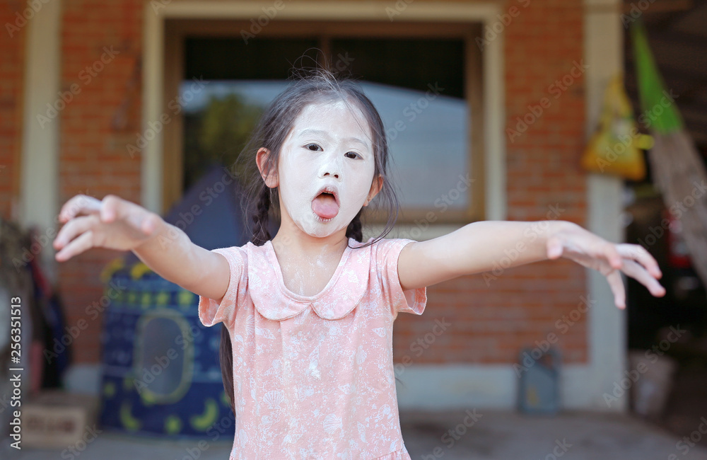 Little Asian child girl playing peekaboo with apply all her face with ...