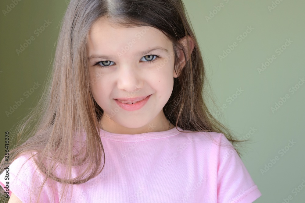 Beautiful green eyed caucasian white girl in a pink T-shirt smiles on ...
