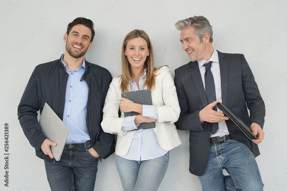 Happy sales team standing together on grey background Stock Photo ...
