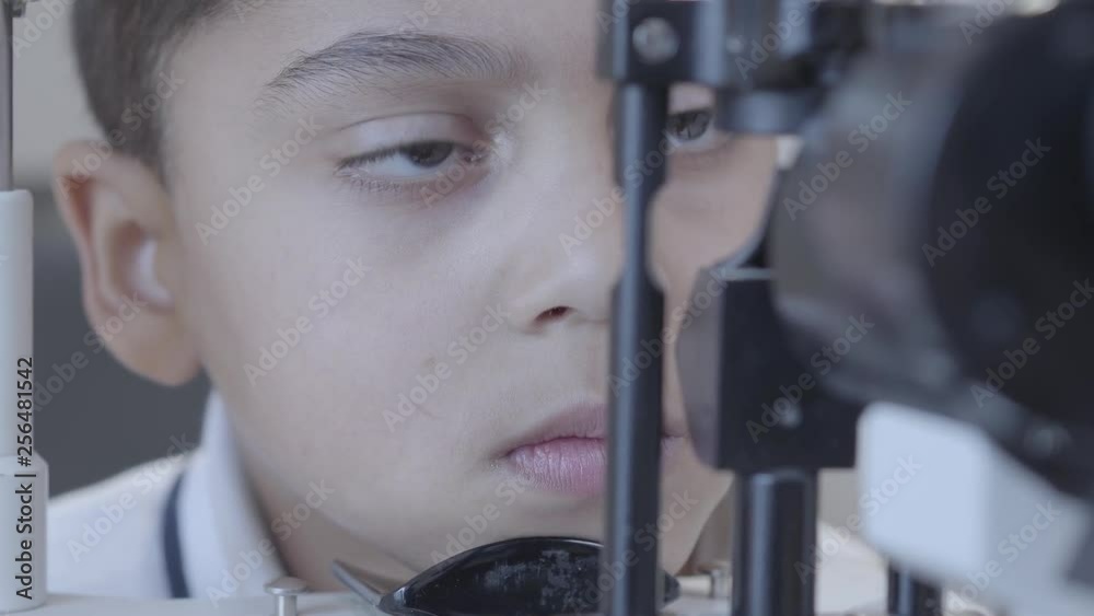 African american little boy doing eye test with optometrist looking at ...