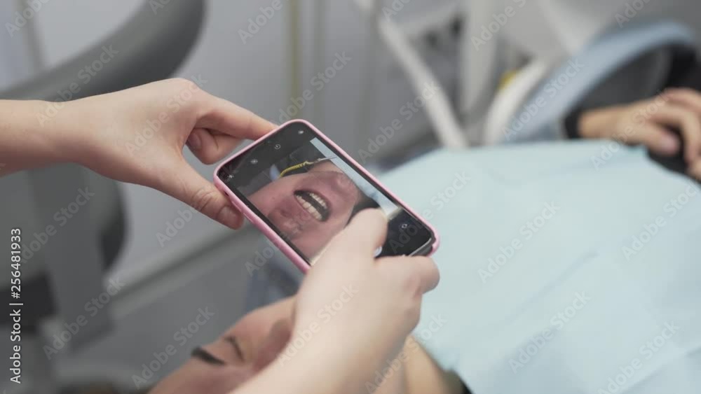 Vidéo Stock Dentist in Modern Dental Clinic Uses Her Mobile Phone ...
