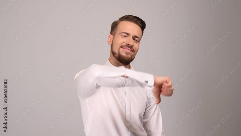 Man showing thumbs down in studio. Close up of unhappy male showing ...